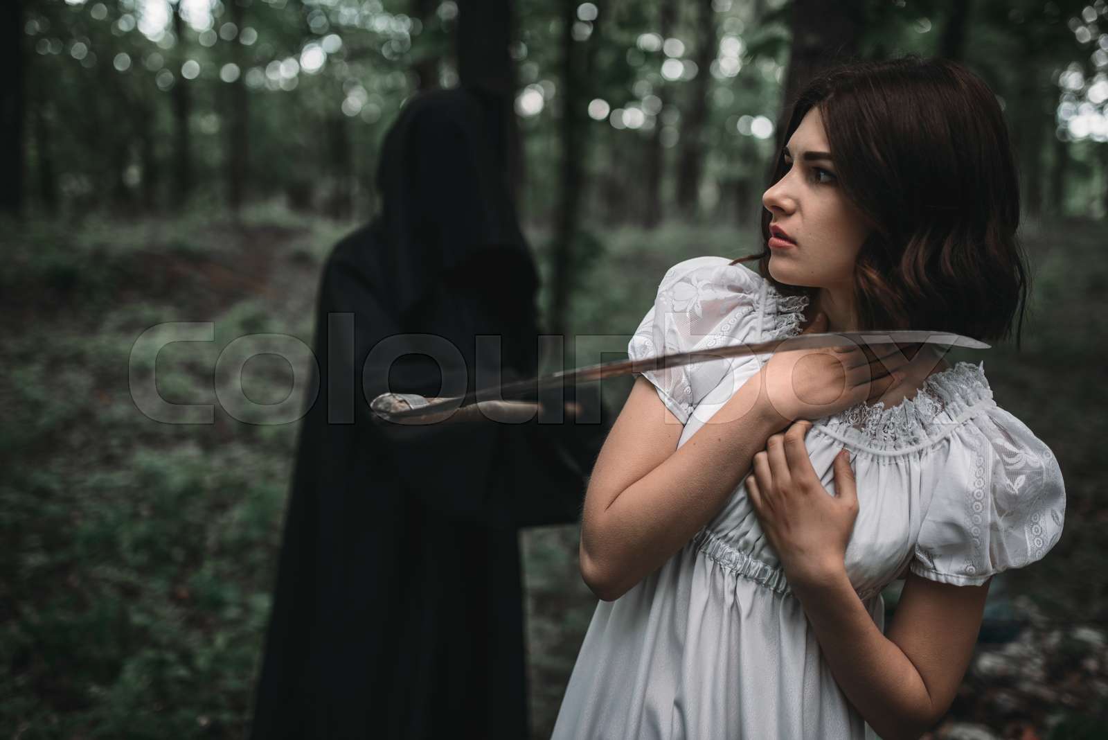 Death swinging a scythe on young female victim | Stock image | Colourbox