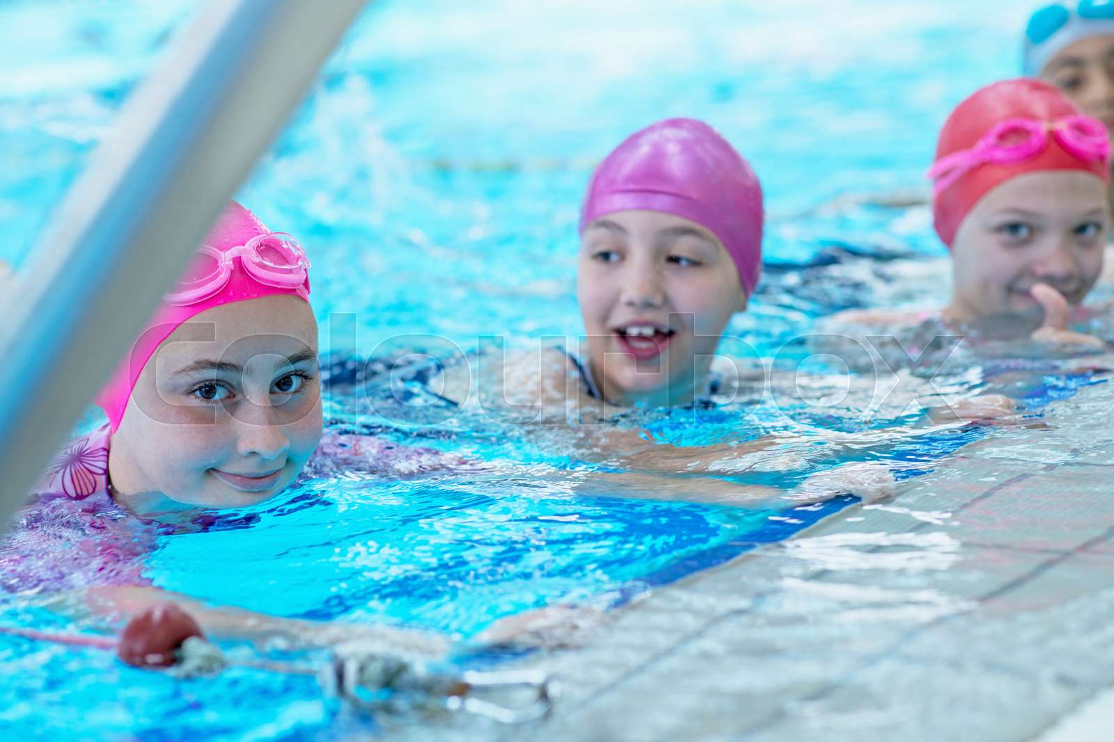 happy kids at the swimming pool. young and successful swimmers pose ...