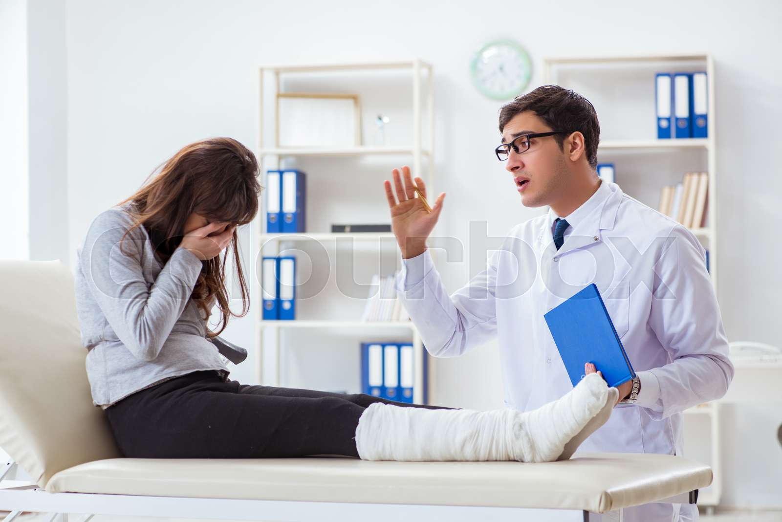 Doctor examining patient with broken leg | Stock image | Colourbox