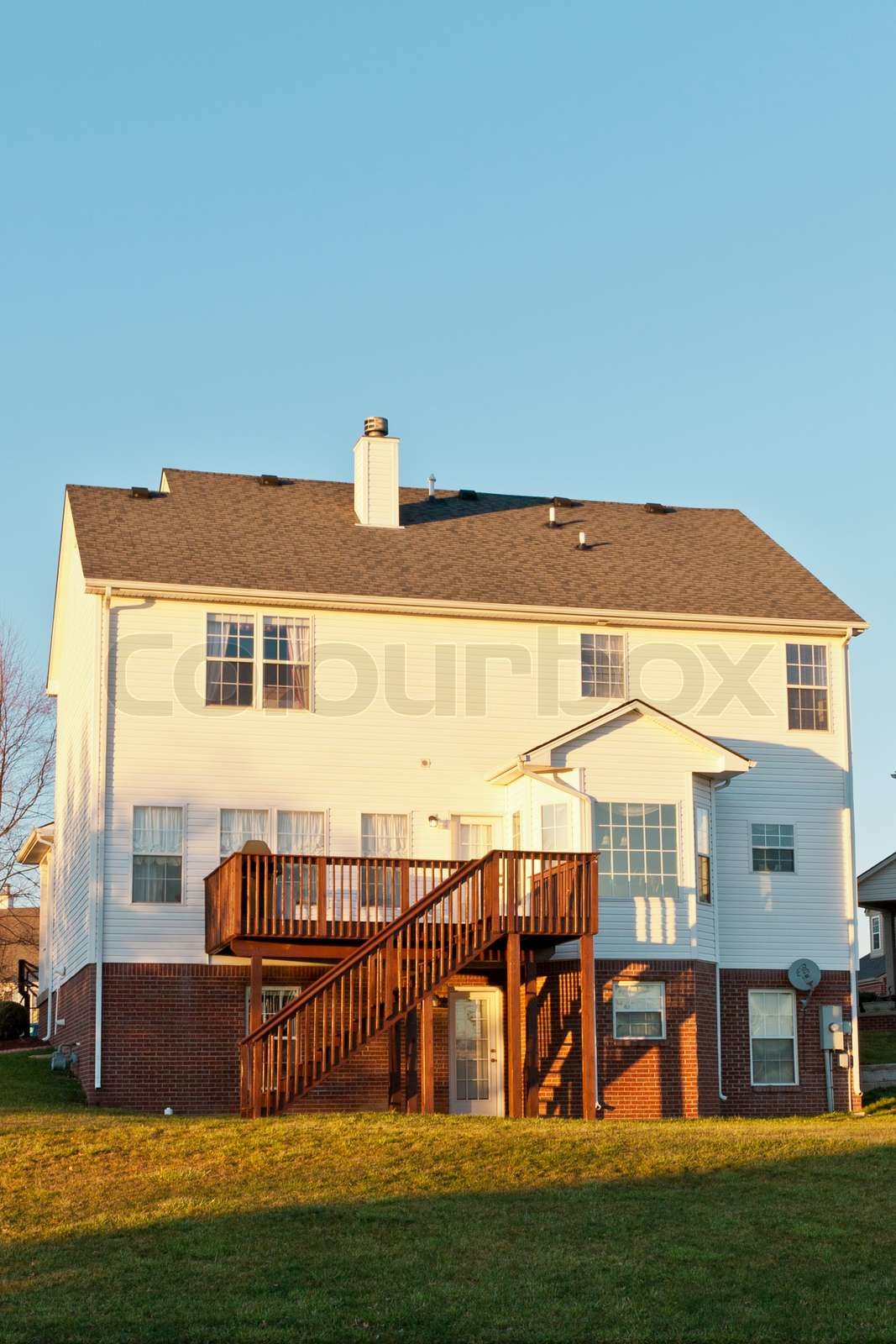 Back view of a typical american two story house with basement and ...