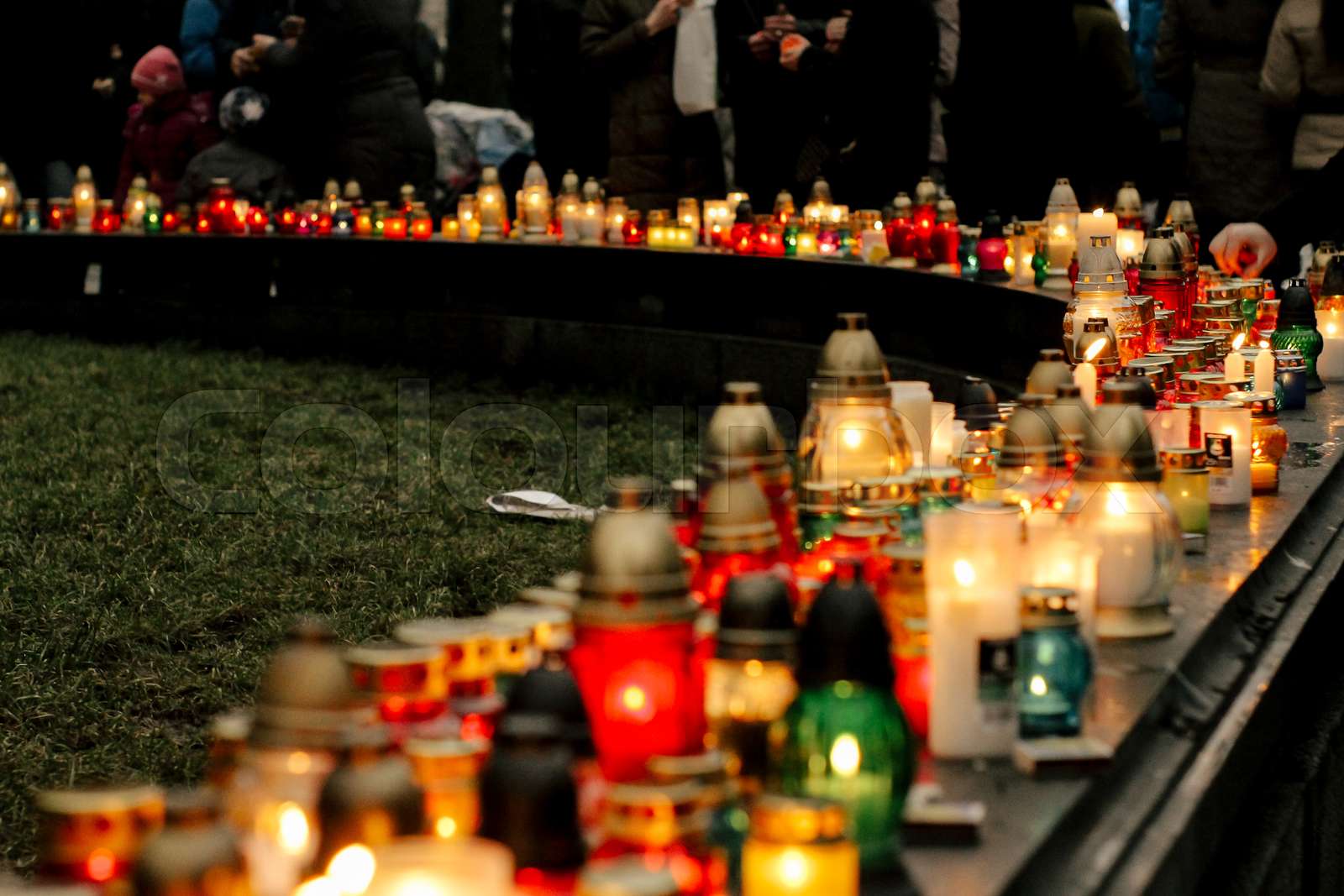 crowd of people lighting candles in city center, mourning victims in ...