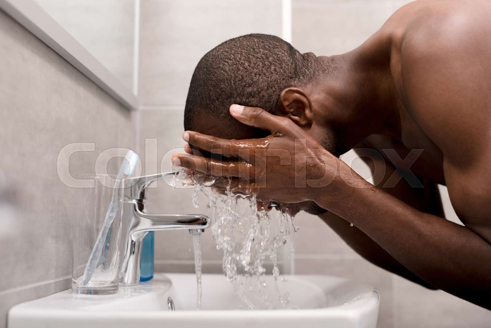 side view of young man washing his face at bathroom in morning | Stock ...