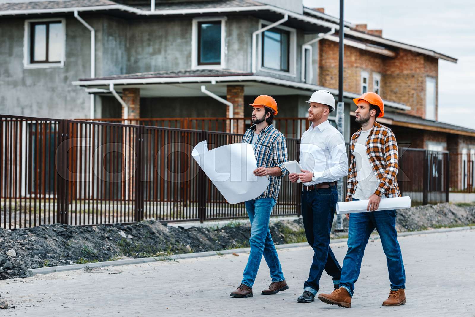 group of architects walking by building street with blueprints | Stock ...