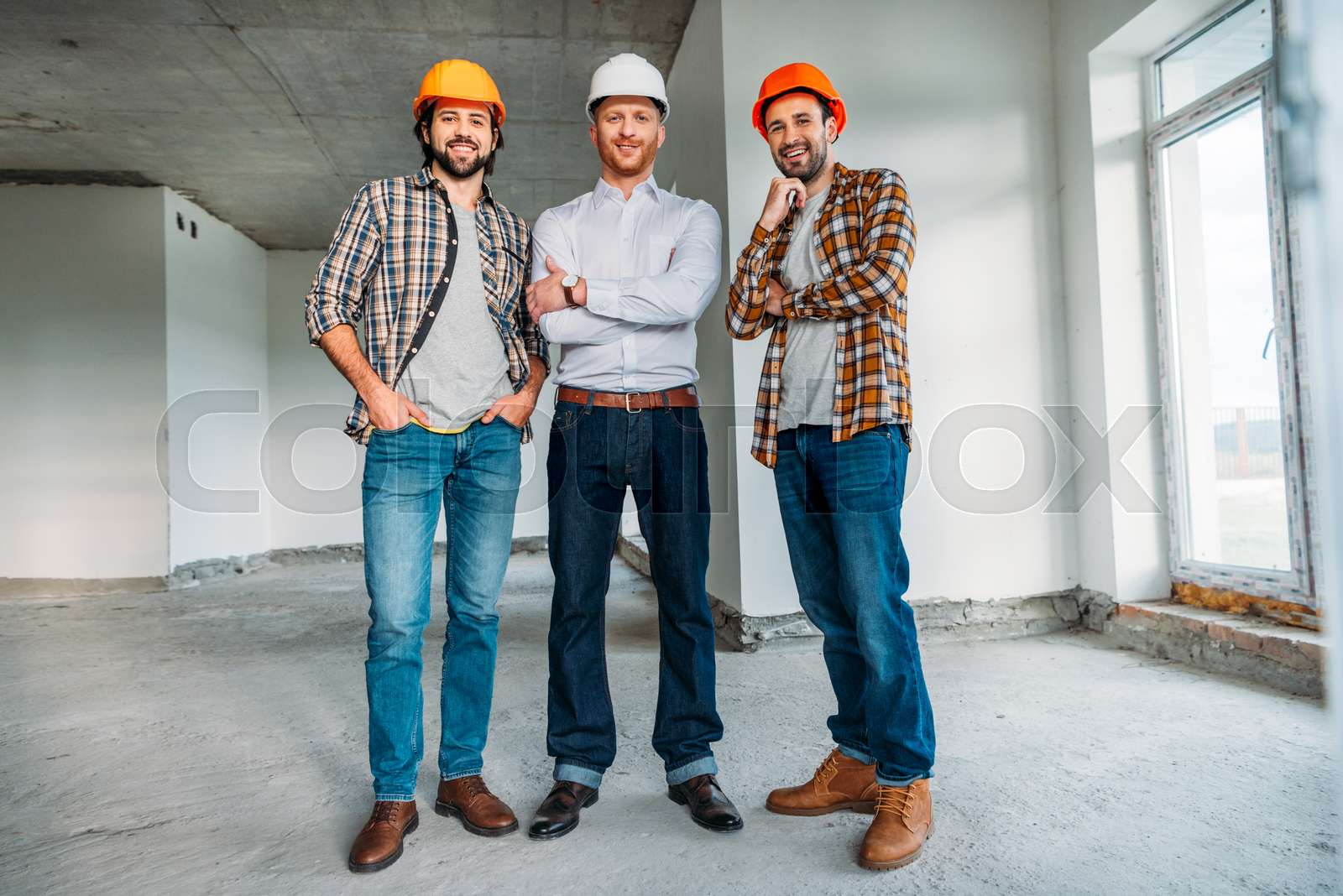 group of architects inside of constructing building looking at camera ...