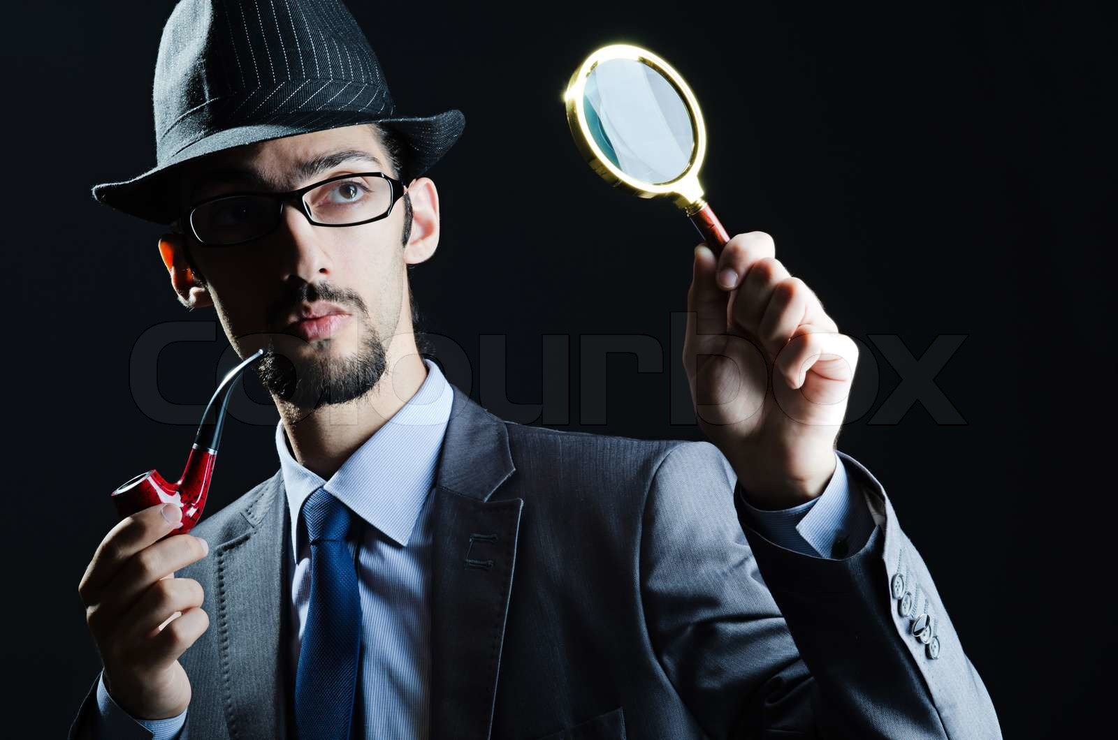 Detective with magnifying glass and pipe | Stock image | Colourbox