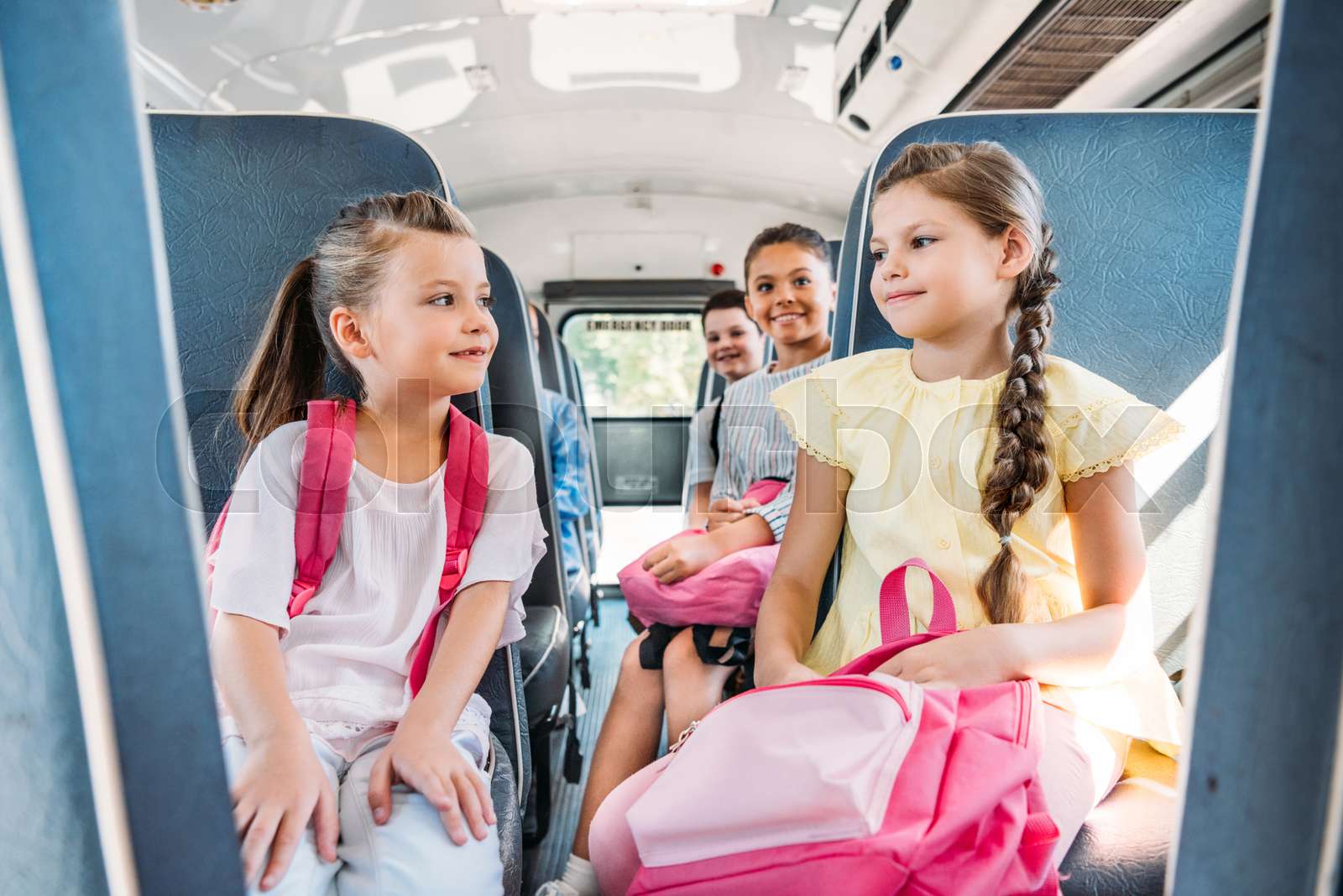 group of happy pupils riding on school bus during school excursion ...