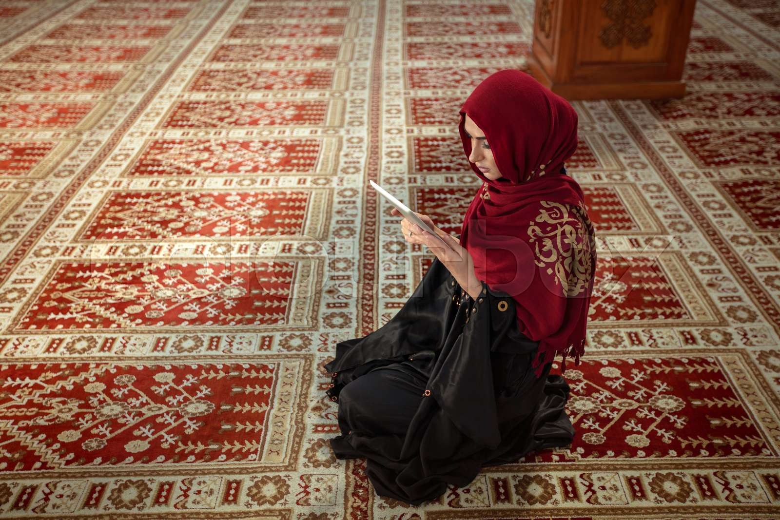 Young muslim woman praying in mosque with quran on tablet | Stock image ...
