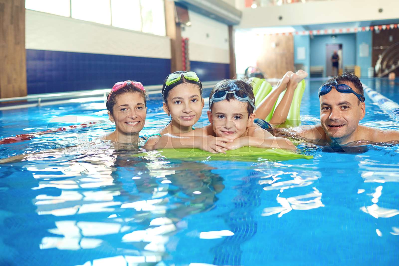A happy family is smiling in a swimming pool. | Stock image | Colourbox