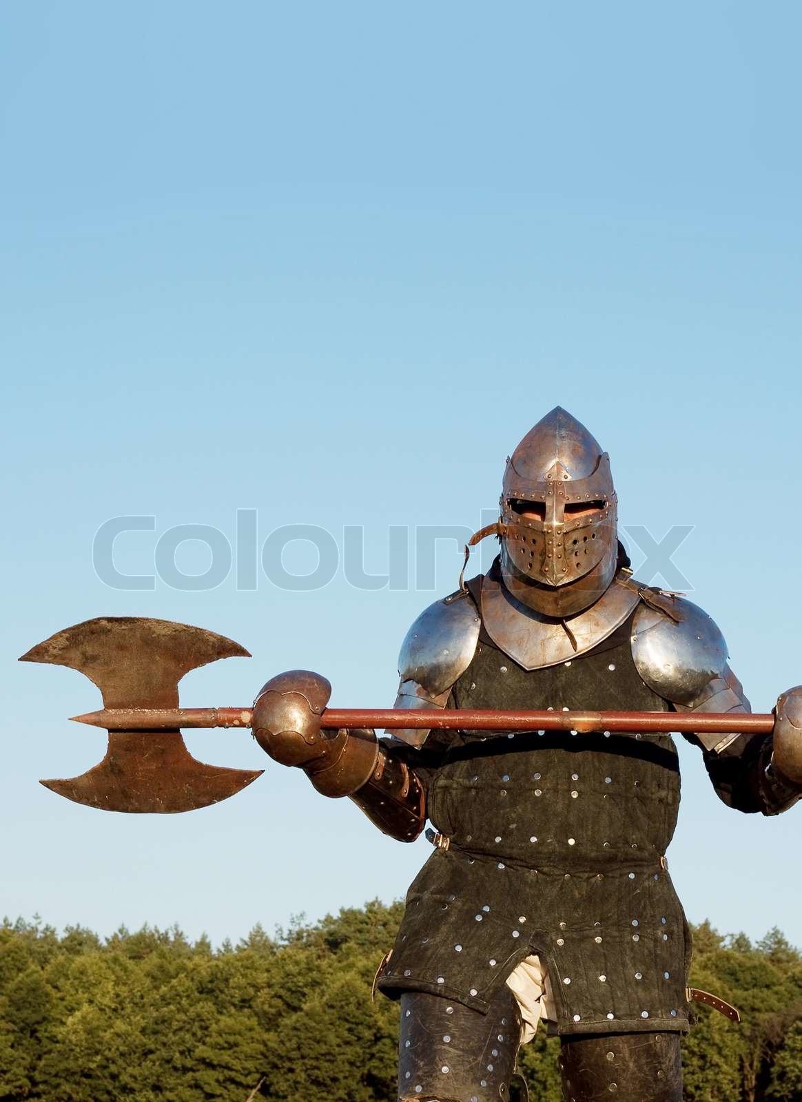 Medieval knight in the field with an axe | Stock image | Colourbox