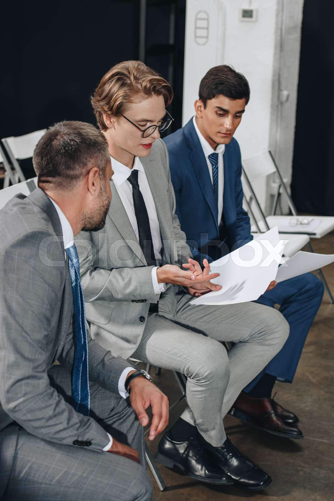 businessmen sitting on chairs during training and talking about ...