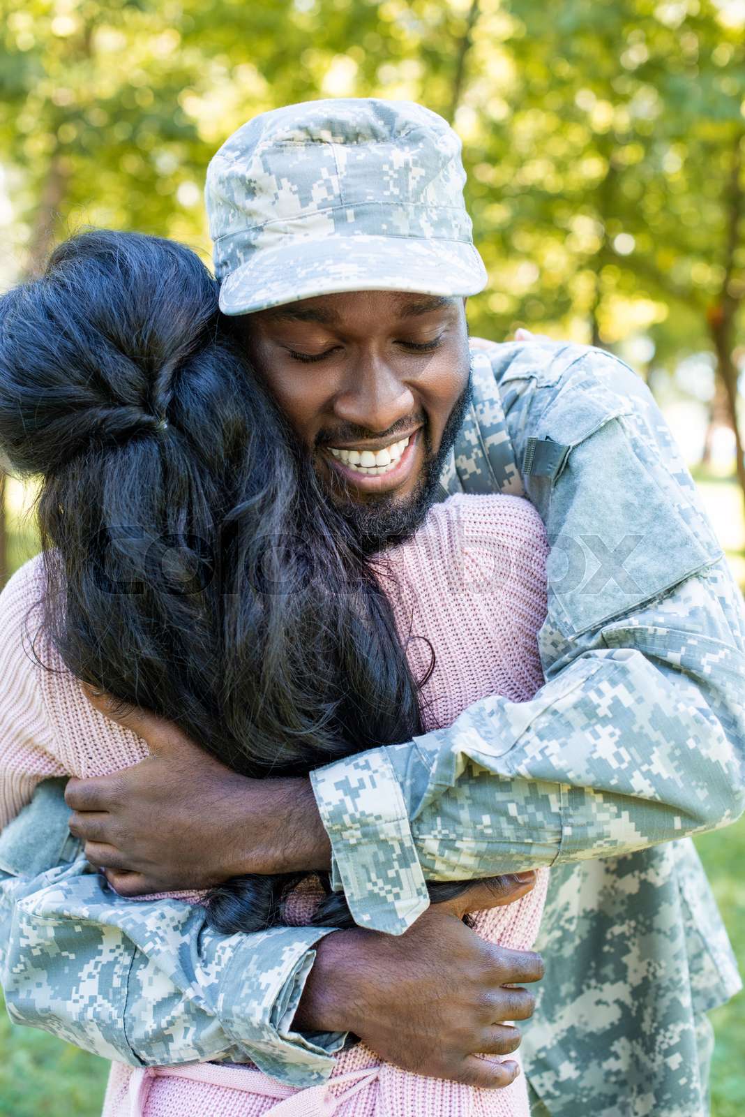 smiling african american soldier in military uniform cuddling ...