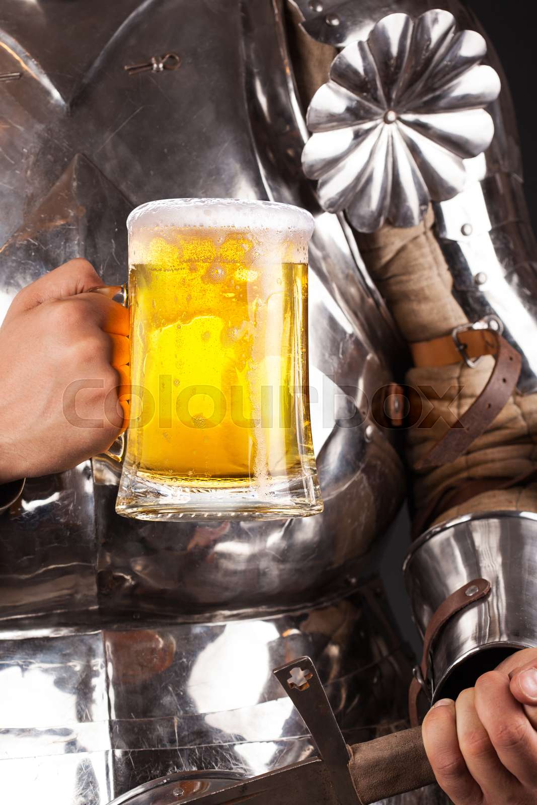 knight wearing armor and holding mug of beer | Stock image | Colourbox
