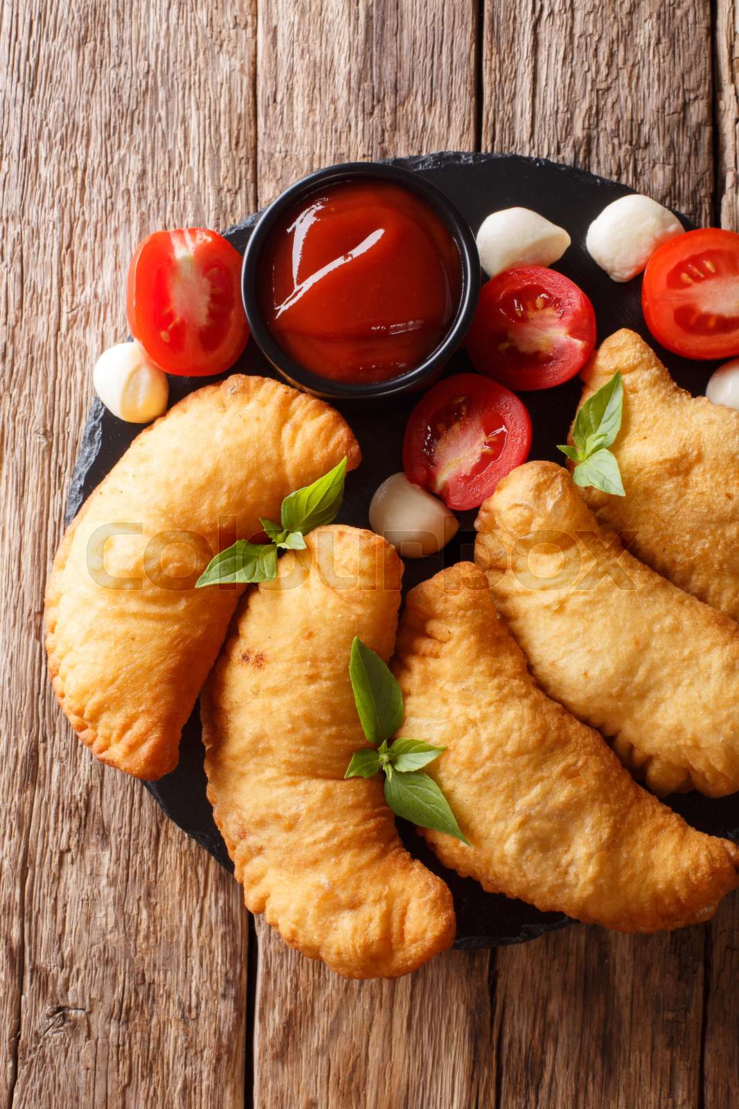 Spicy typical street Italian food: fried panzerotti with tomato sauce ...