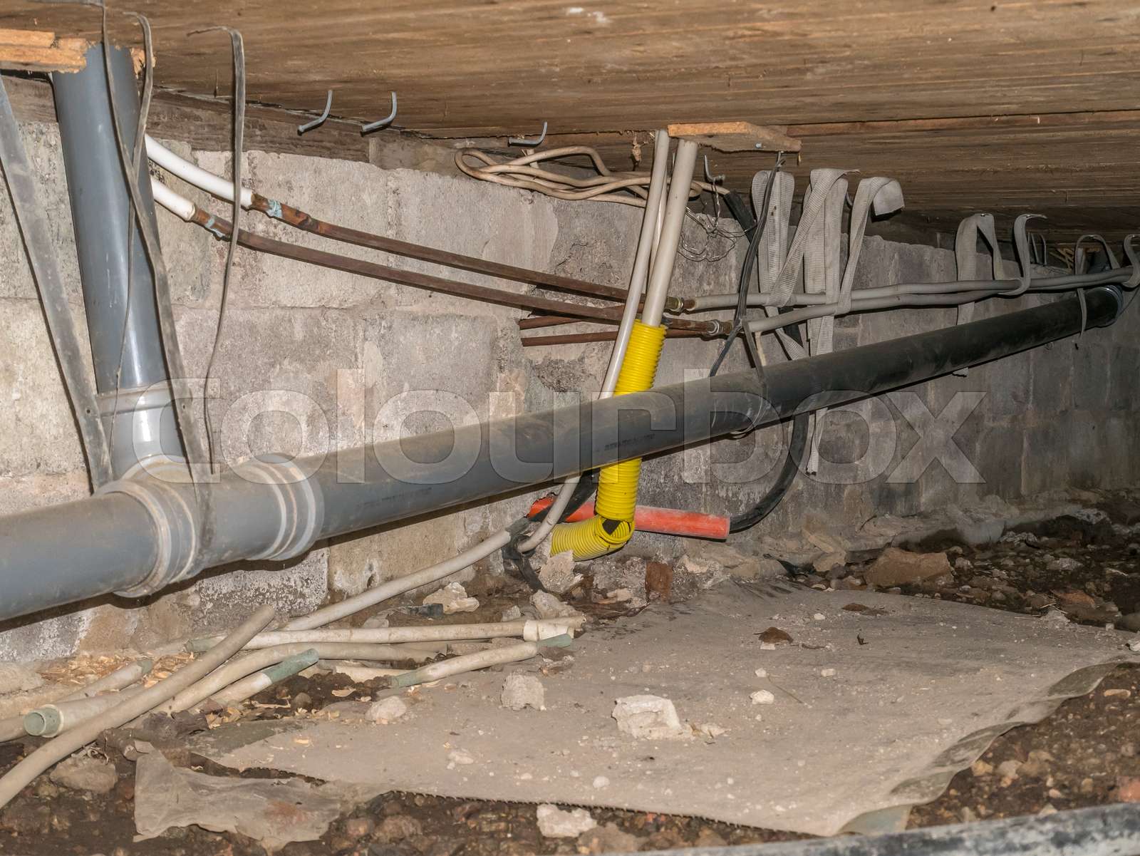 Suspended foundation under old house is often called crawl. Pipes for ...