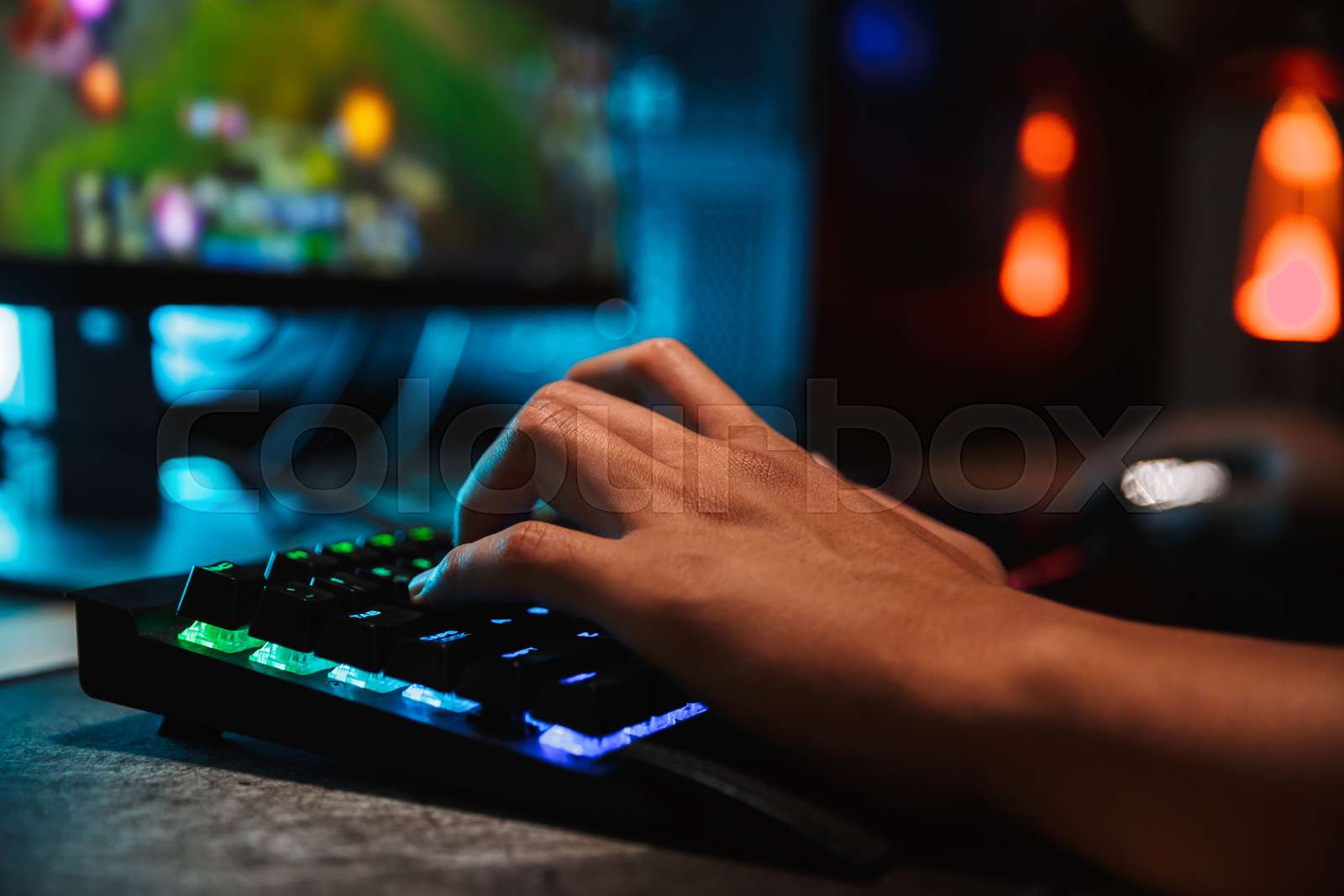 Hands of professional gamer man playing video games on computer in dark ...