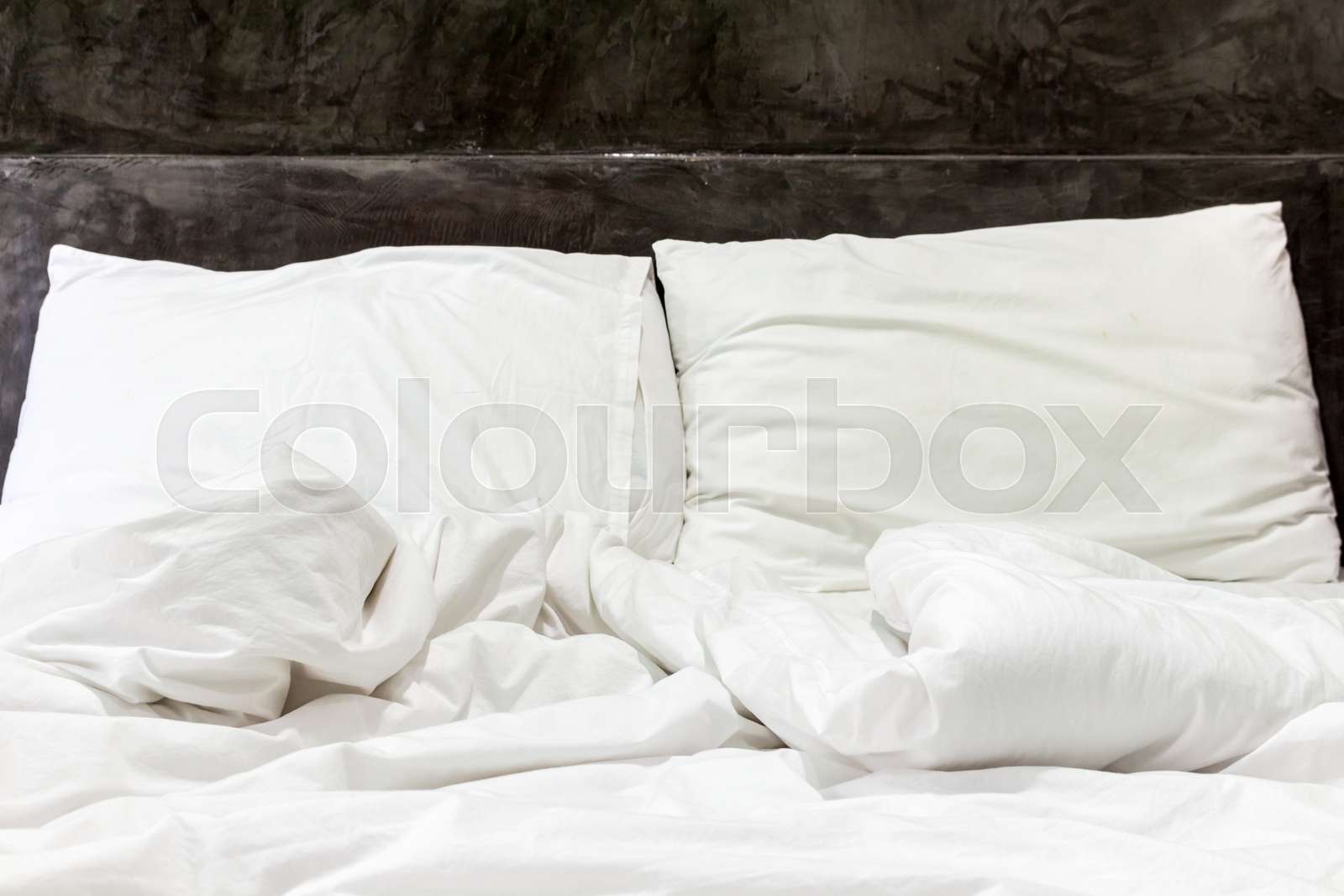 Messy and unmade bed in hotel room | Stock image | Colourbox
