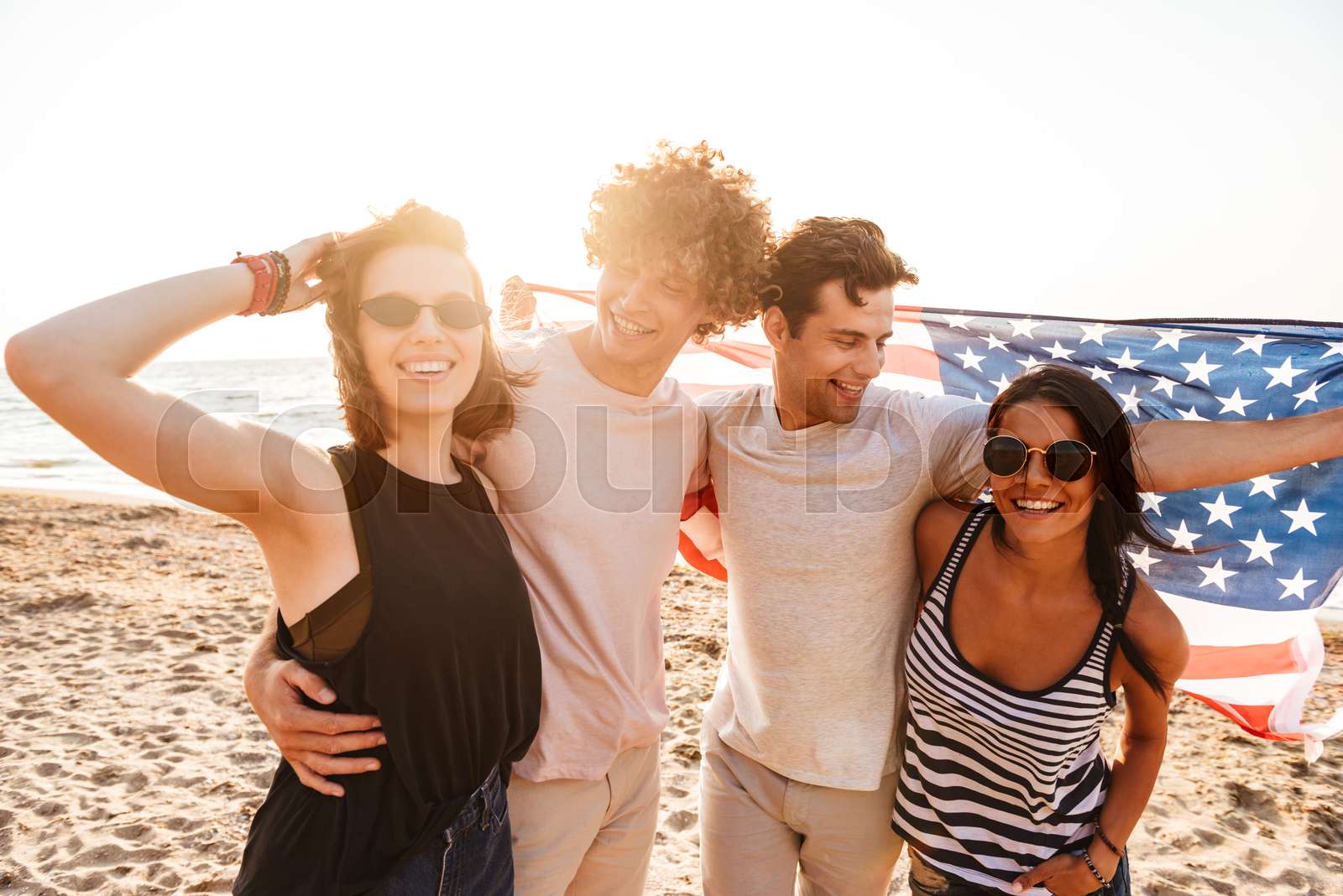 Happy group of friends holding USA flag having fun. | Stock image ...