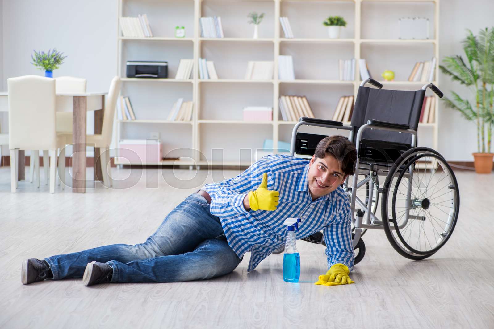Disabled man on wheelchair cleaning home | Stock image | Colourbox