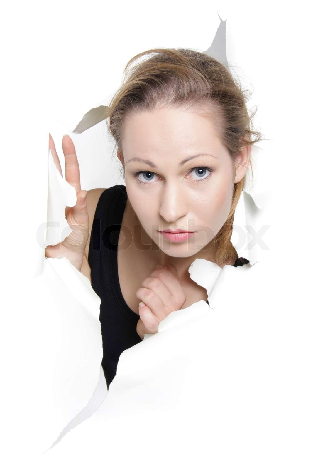 Frau schaut aus Loch in Papier | Stock Bild | Colourbox