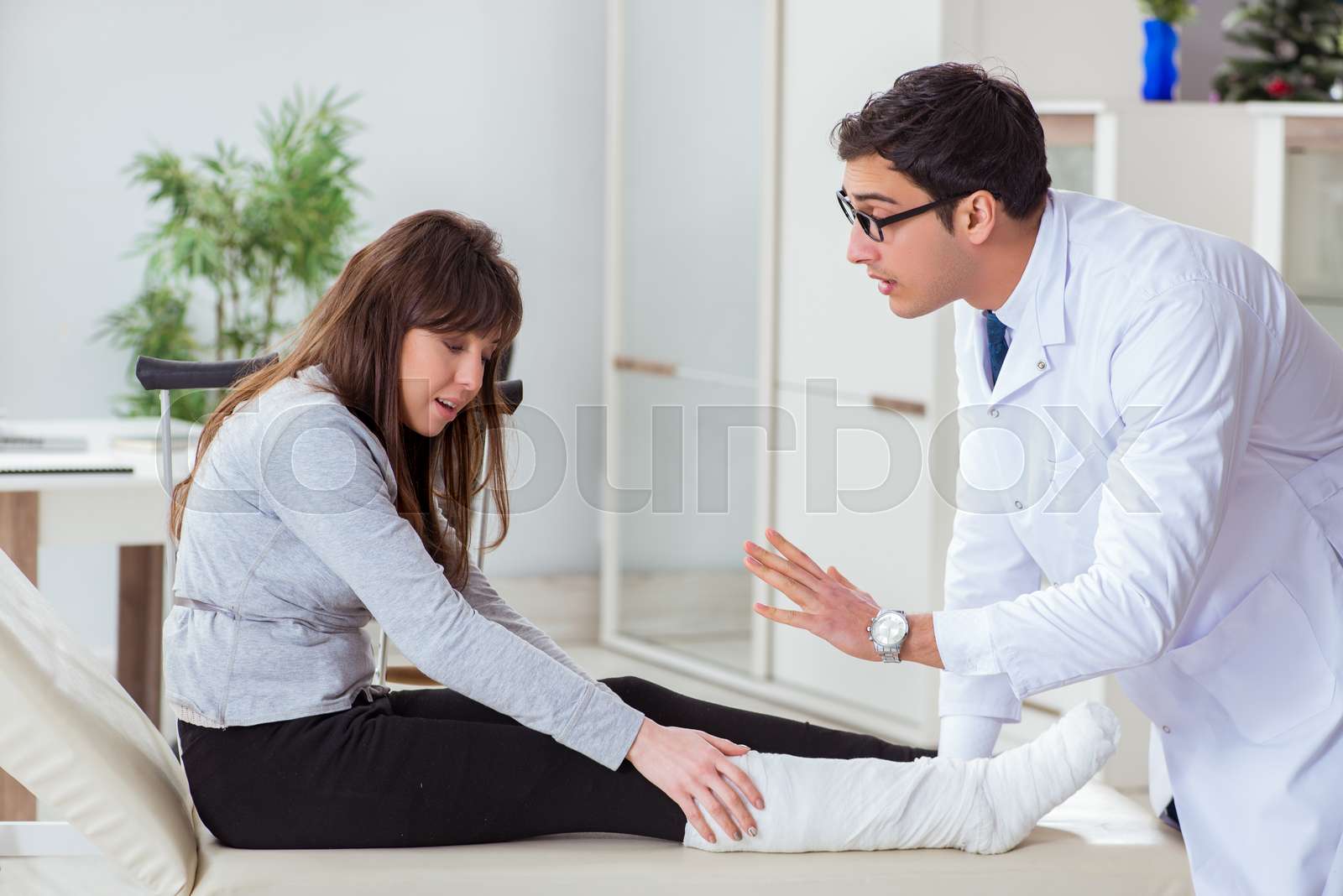 Doctor examining patient with broken leg | Stock image | Colourbox