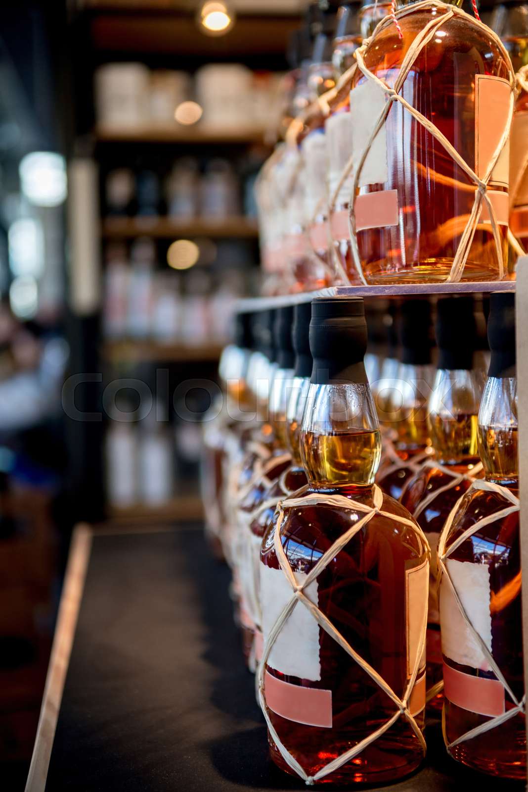 selective focus of whiskey bottles placed in rows on shelves in shop ...