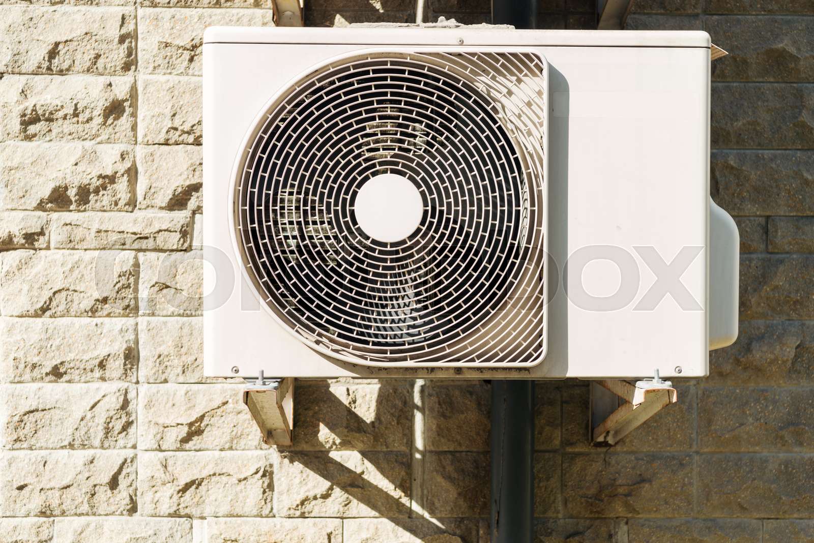 white air conditioner hanging on wall at sunny day | Stock image ...