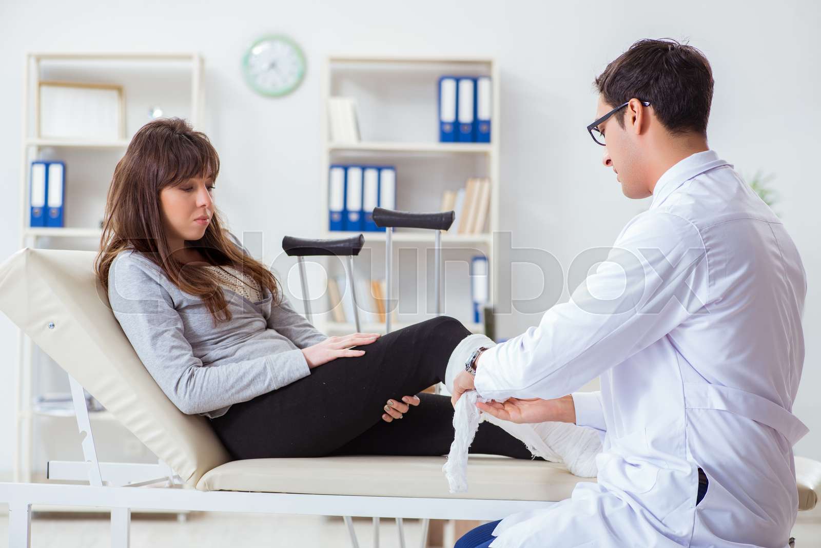 Doctor examining patient with broken leg | Stock image | Colourbox