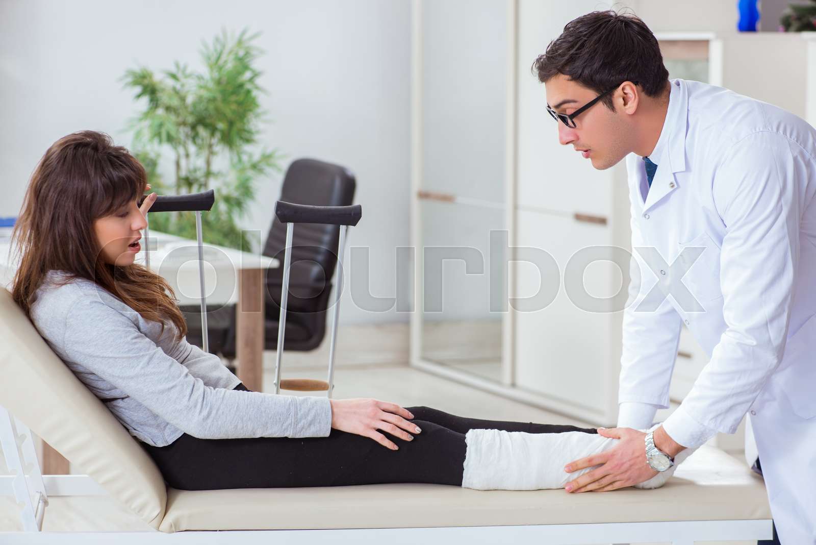 Doctor examining patient with broken leg | Stock image | Colourbox