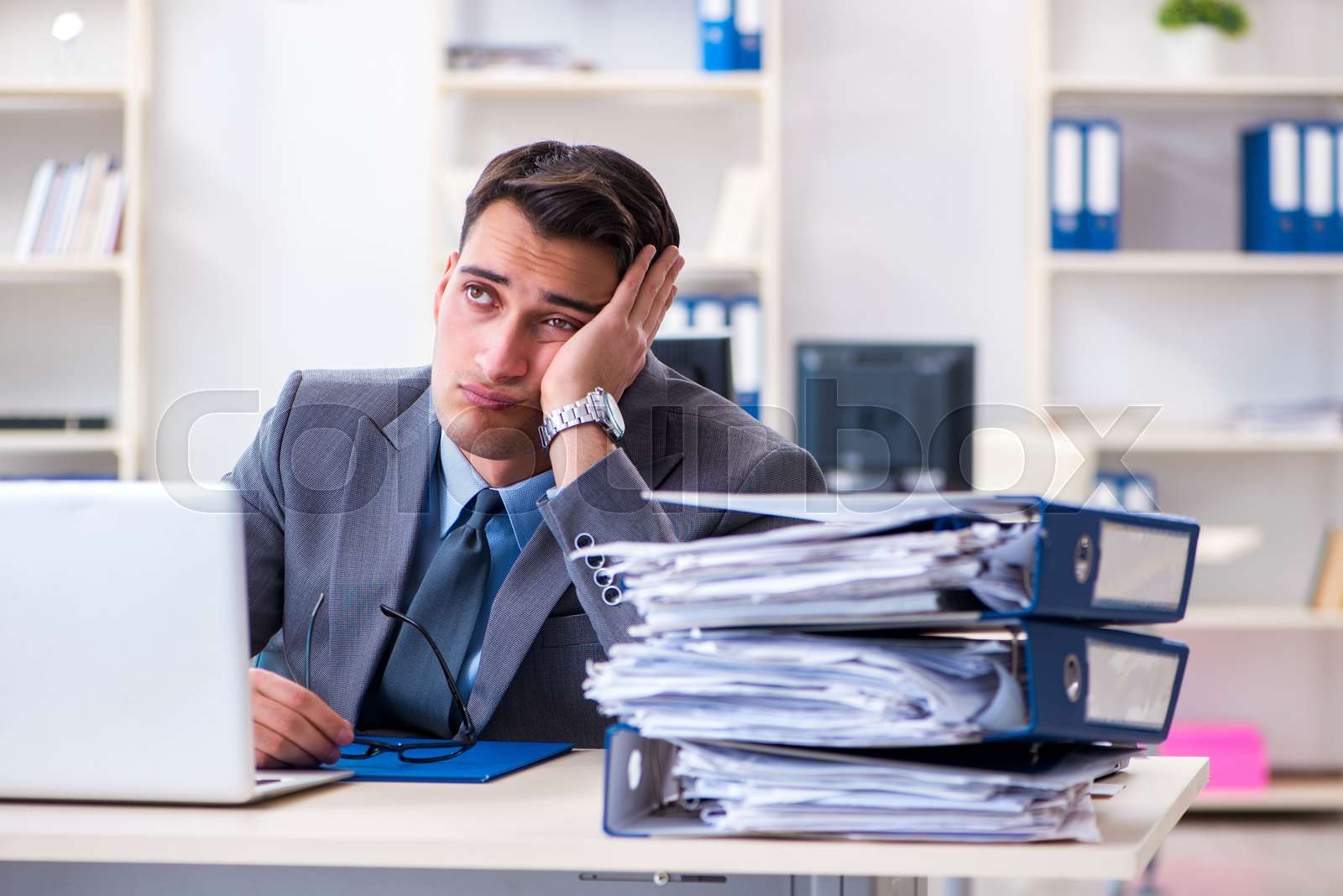 Overloaded with work employee under paperwork burden | Stock image ...