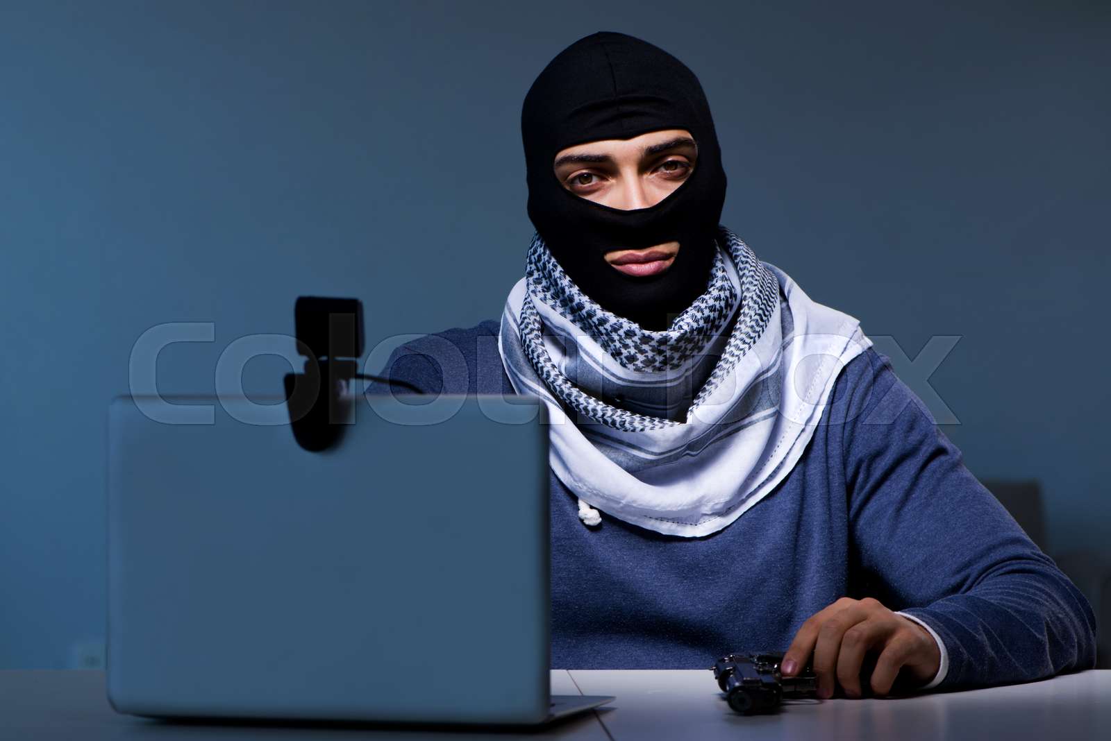 Hacker wearing balaclava mask hacking computer | Stock image | Colourbox