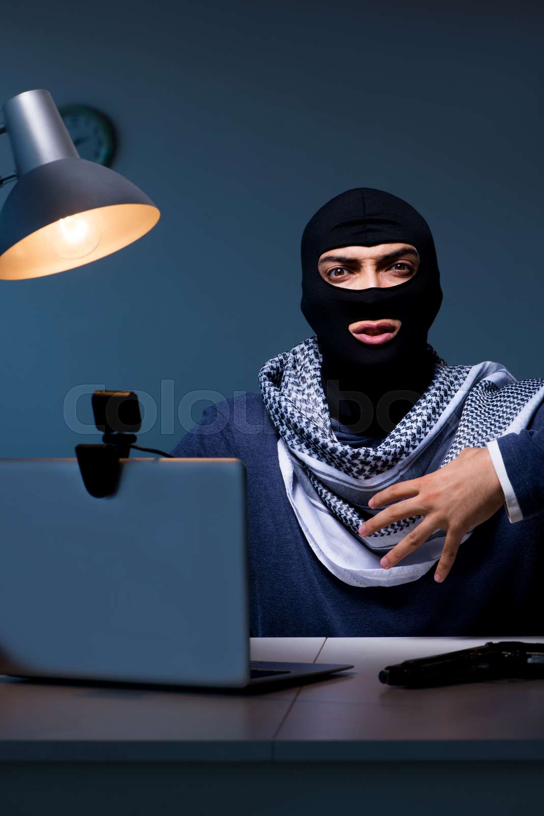 Hacker wearing balaclava mask hacking computer | Stock image | Colourbox