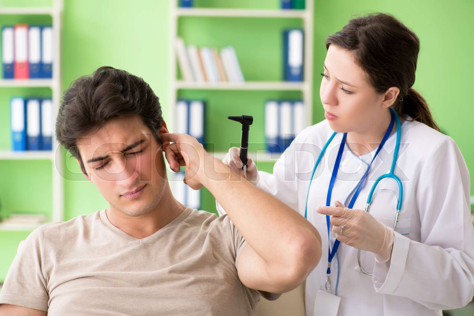 Female doctor checking patient's ear during medical examination | Stock ...