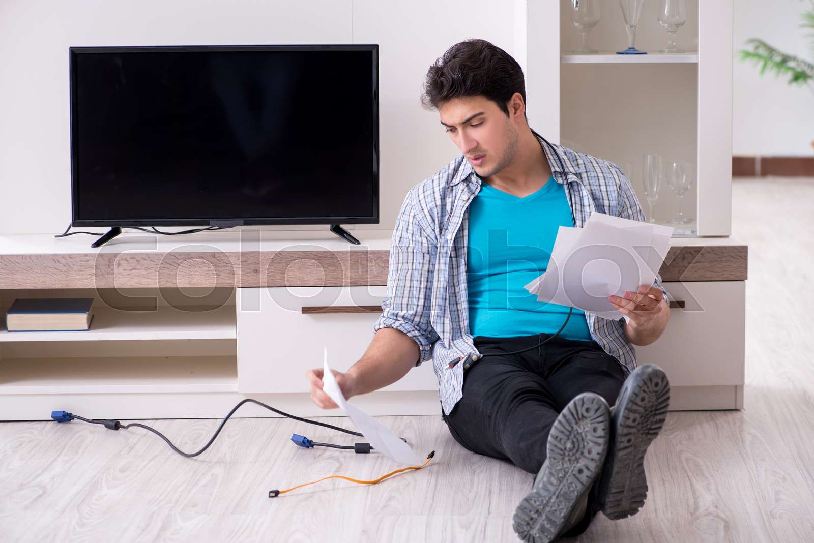 Man trying to fix broken tv | Stock image | Colourbox