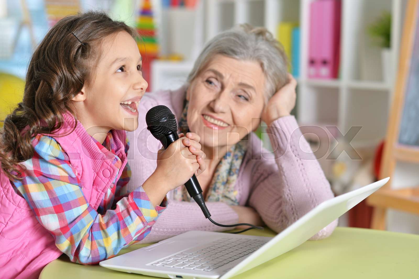 Portrait of grandmother and daughter singing karaoke | Stock image ...