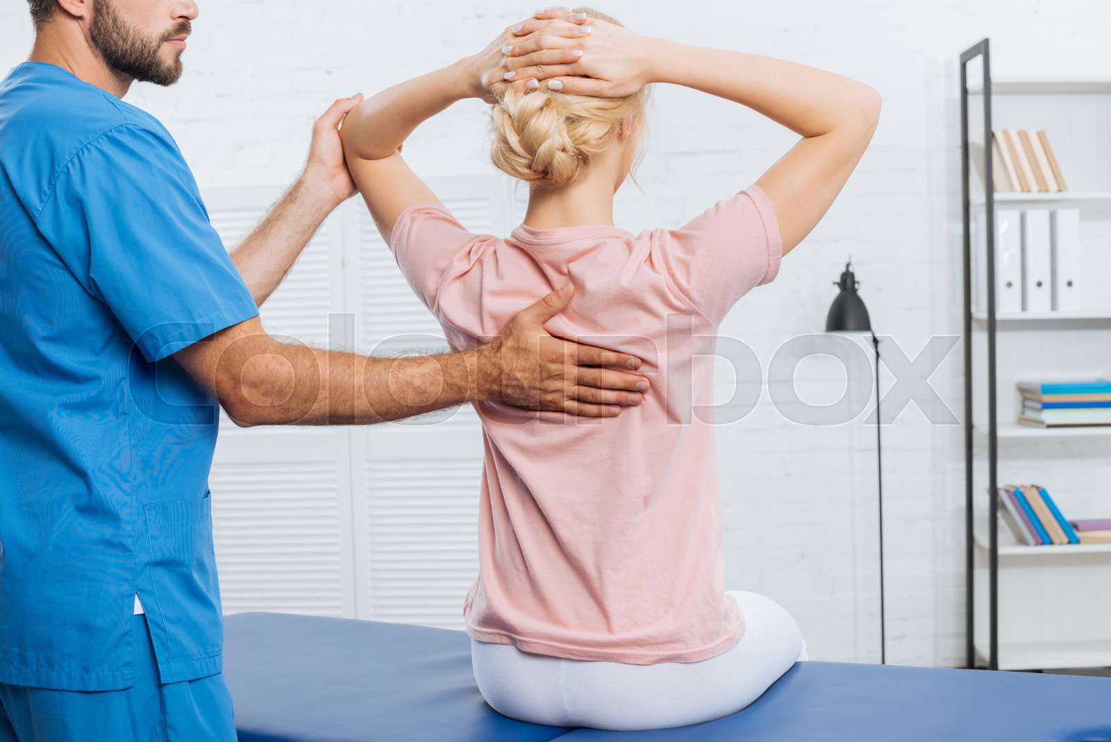 partial view of physiotherapist doing massage to woman on massage table ...