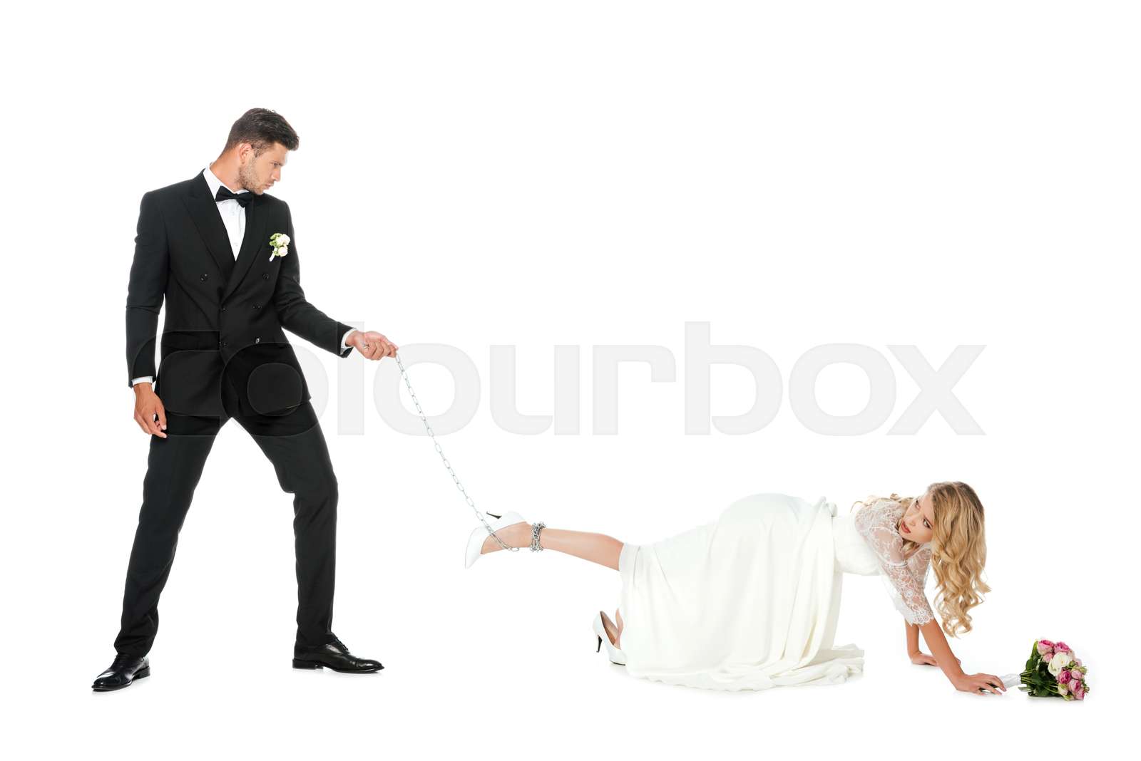 handsome groom holding chain tied around brides leg isolated on white ...