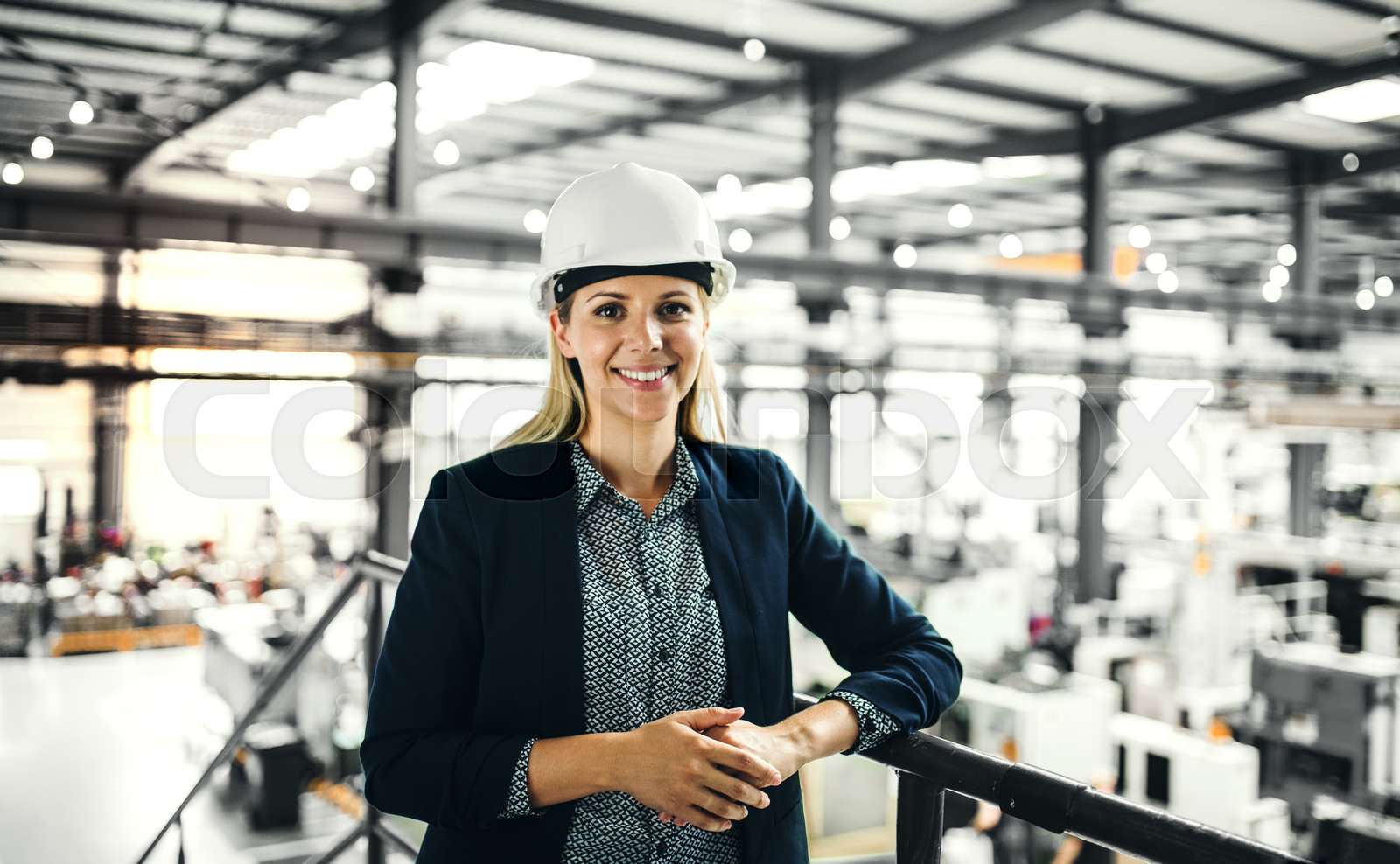 A portrait of an industrial woman engineer standing in a factory ...
