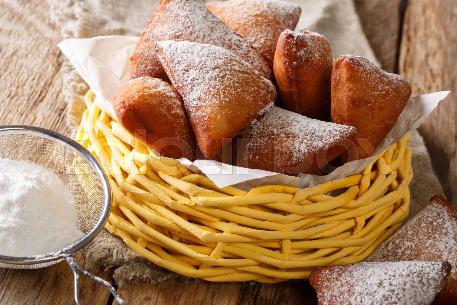 Deep fried African Mandazi donuts with powdered sugar close up on the ...