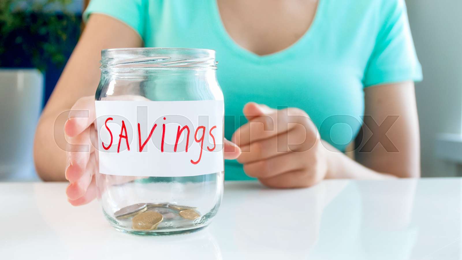 Closeup photo of young woman taking almost empty glass jar for money ...