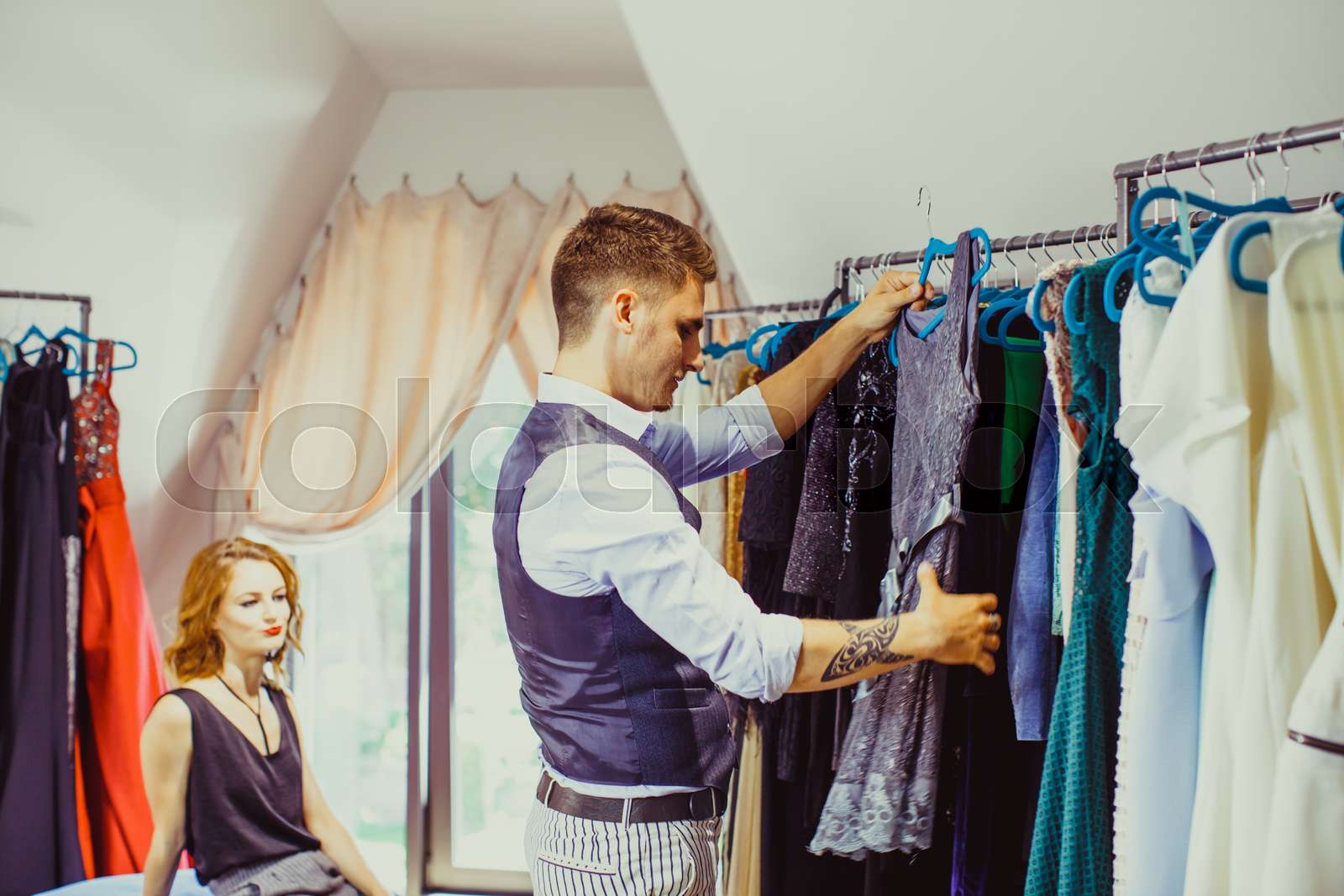 Husband helps to choose dress for his wife | Stock image | Colourbox
