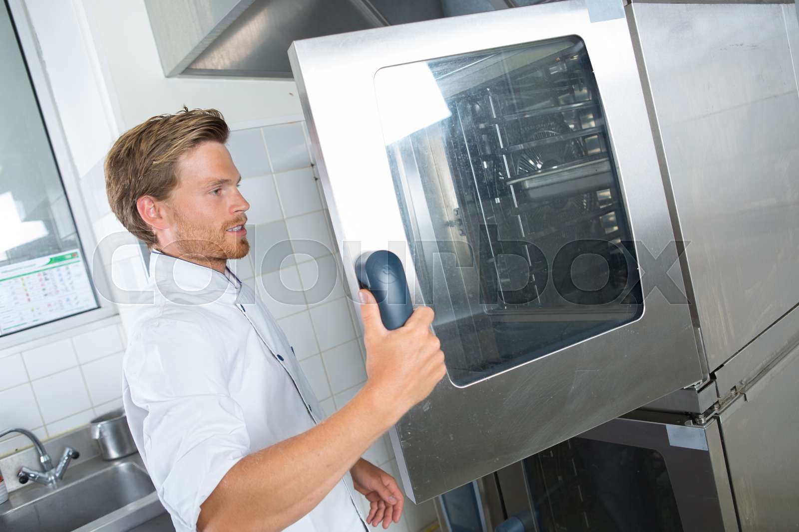 man opening the big oven | Stock image | Colourbox
