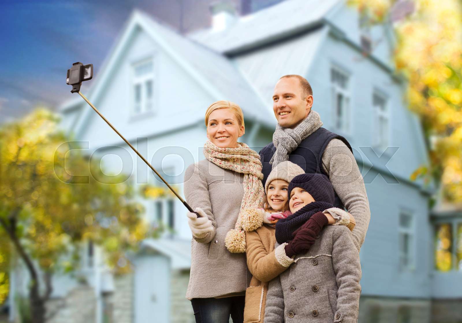 family takes autumn selfie by cellphone over house - Stock Image ...