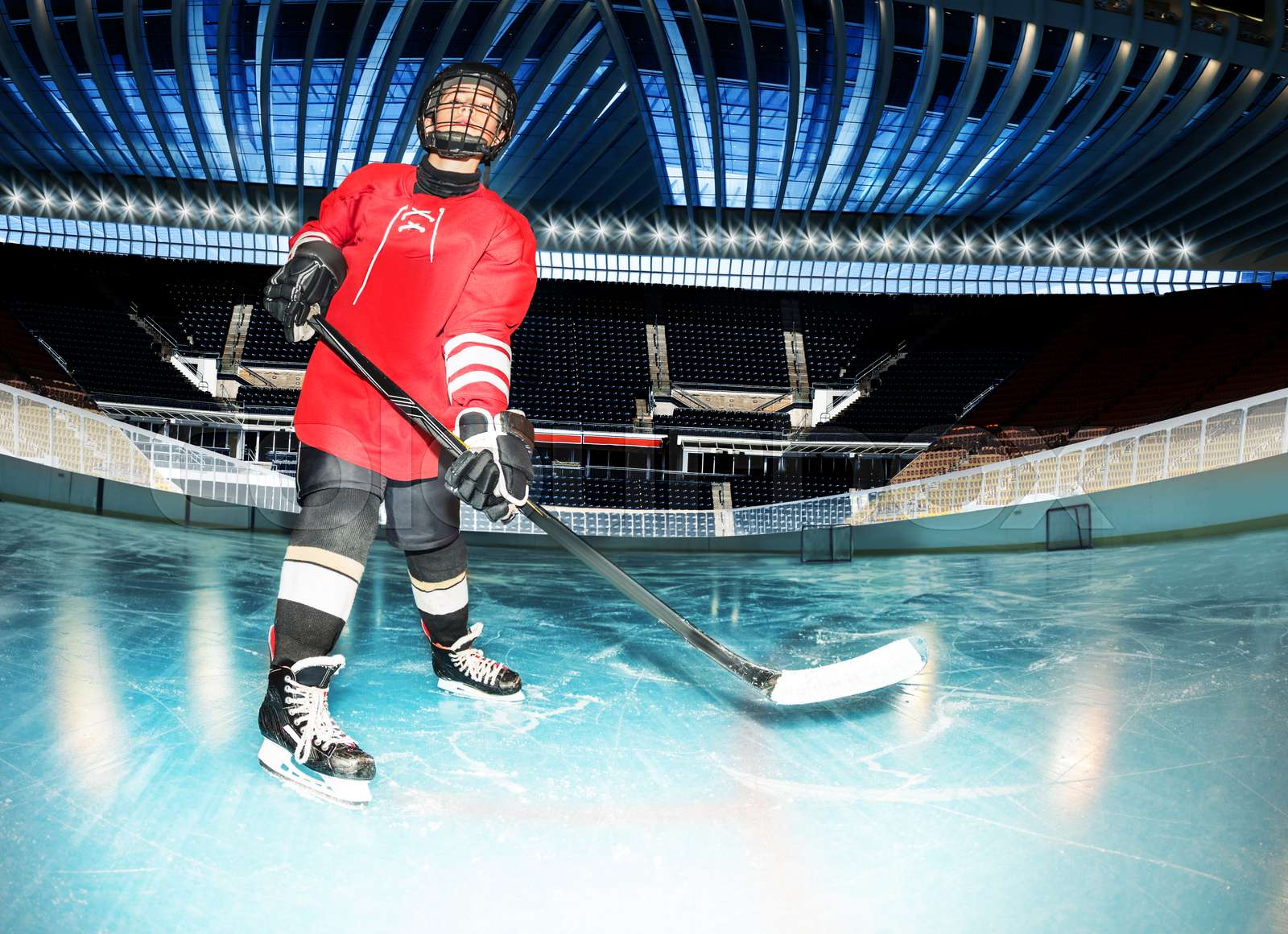 Player with stick on ice rink of hockey stadium | Stock image | Colourbox