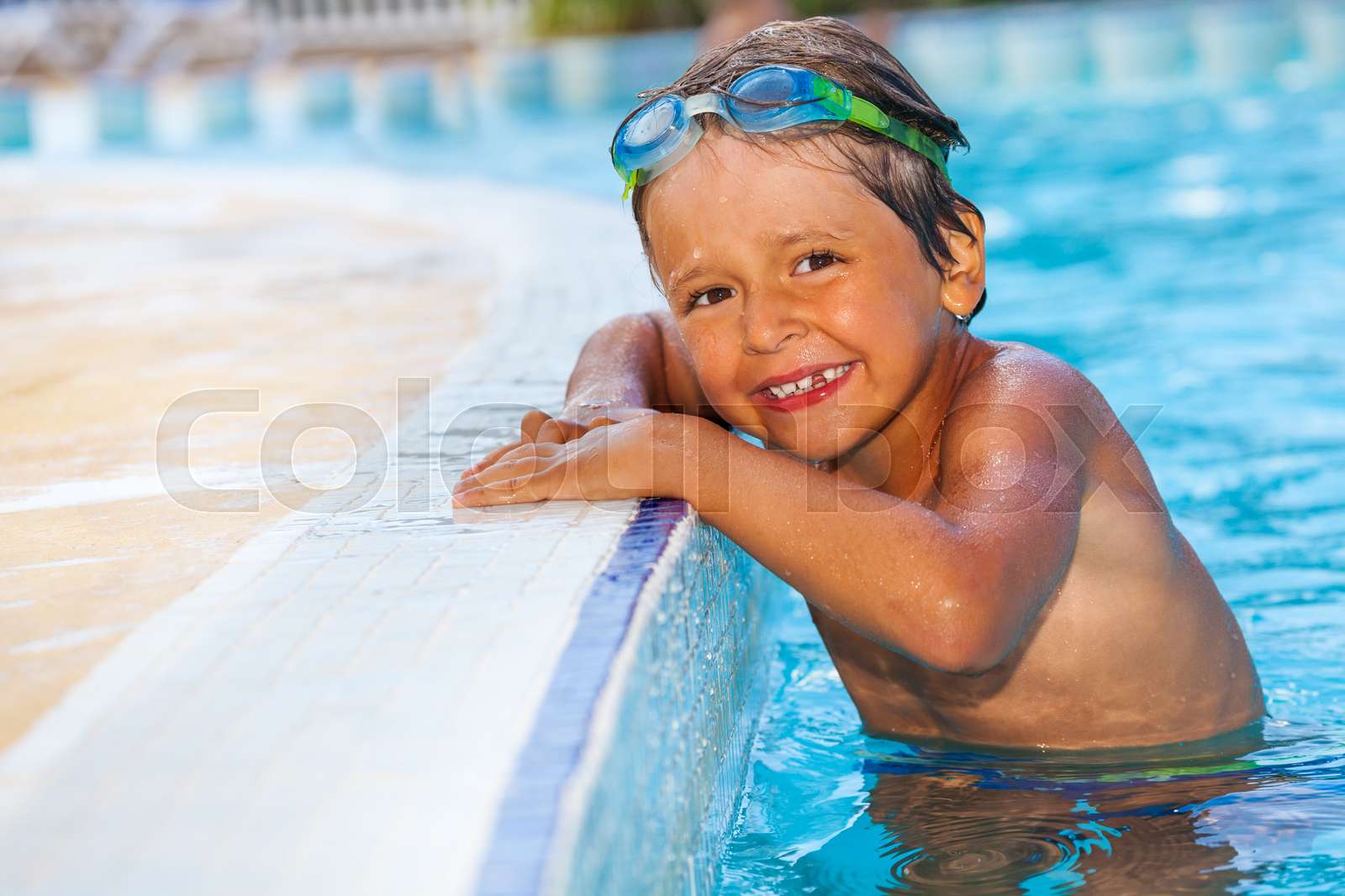 Smiling boy standing in water of swimming pool | Stock image | Colourbox