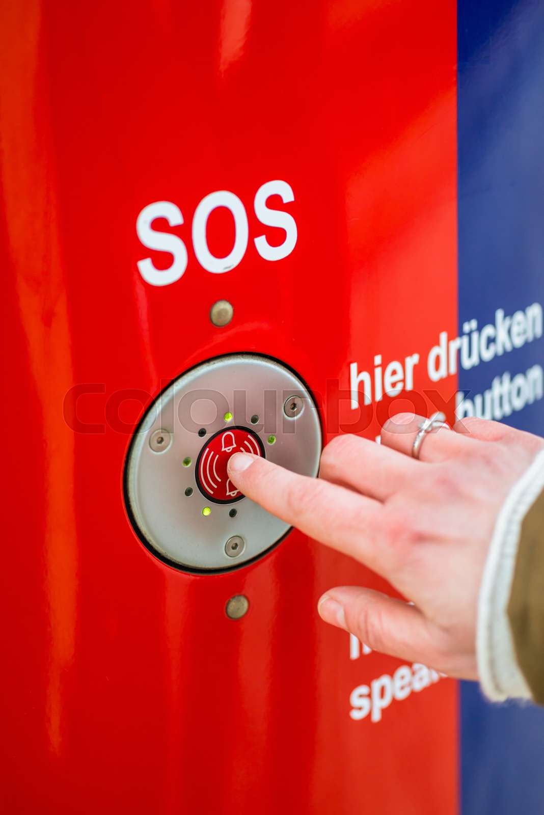 Woman pressing SOS emergency button in train station | Stock image ...