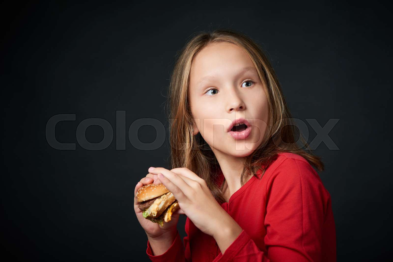 Girl holding going to eat a burger looking back over shoulder with a ...