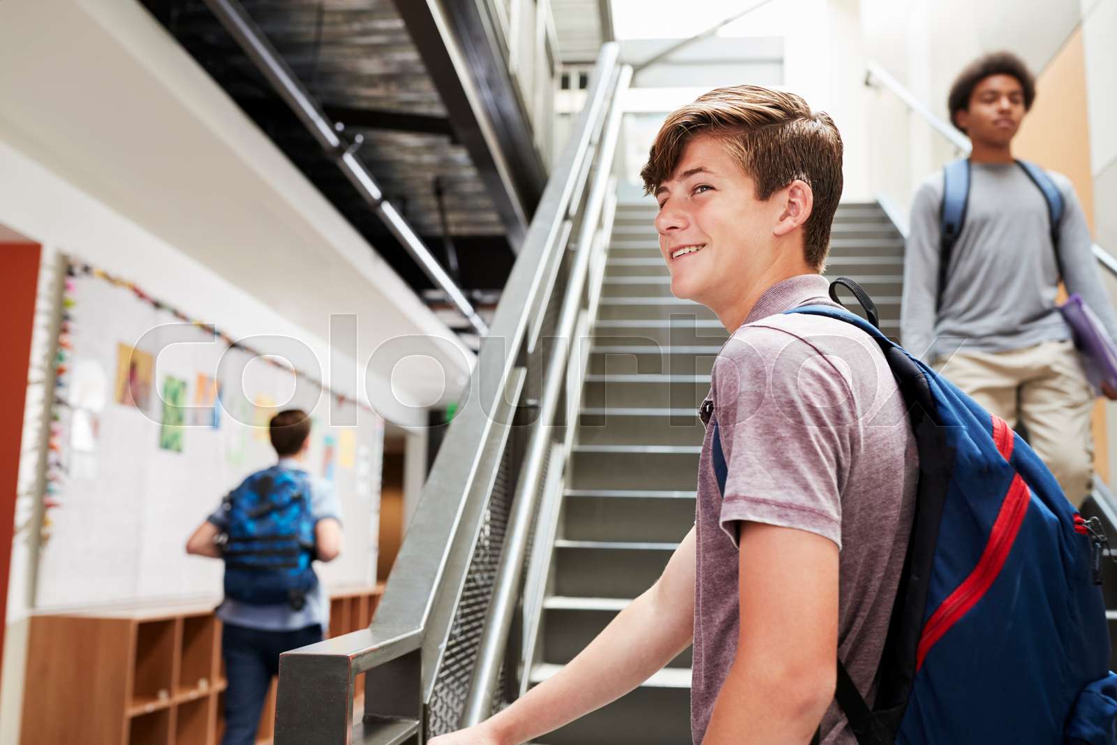High School Students Walking Down Stairs In Busy College Building ...