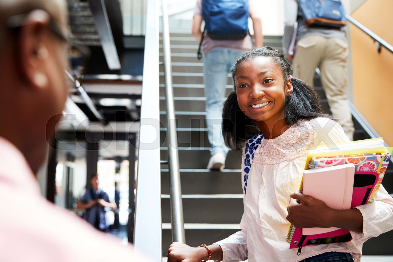 Female High School Student Talking With Teacher In Busy Corridor ...
