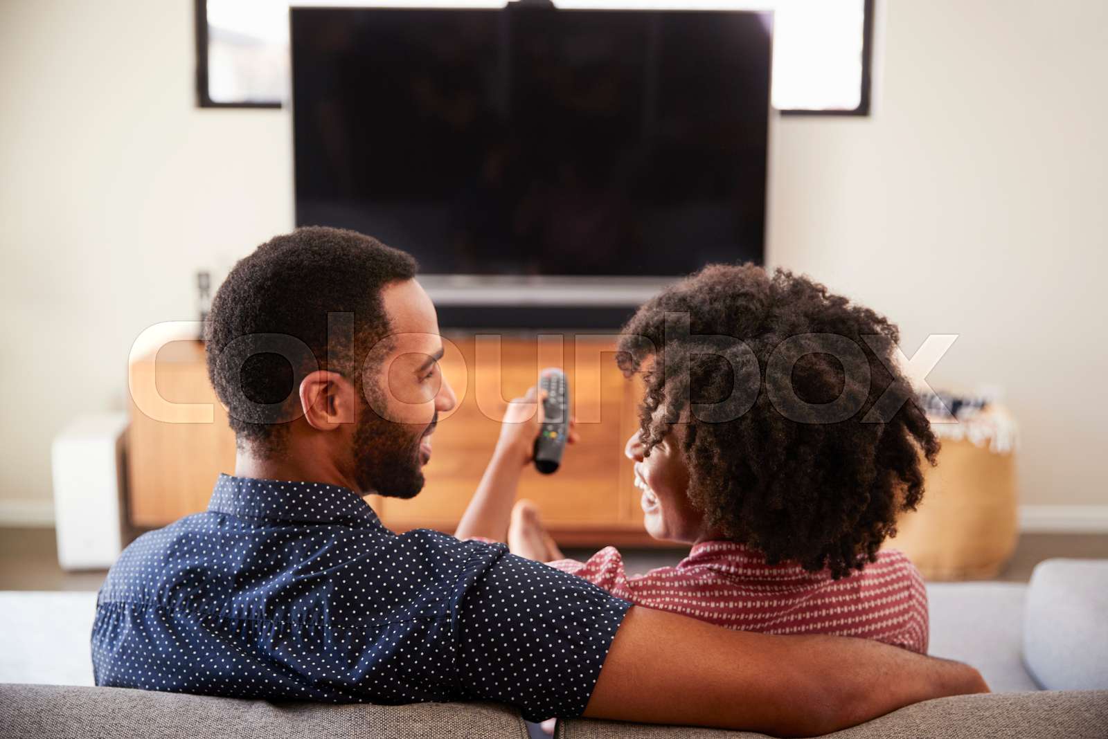 Rear View Of Couple Sitting On Sofa Watching TV Together | Stock image ...