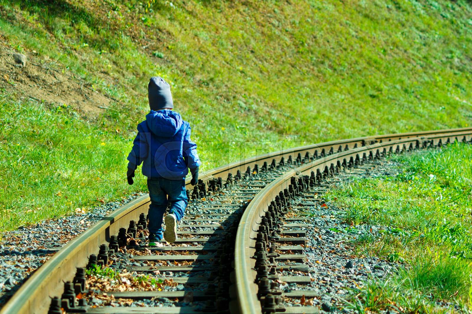 A young tourist is walking on a railroad track. | Stock image | Colourbox